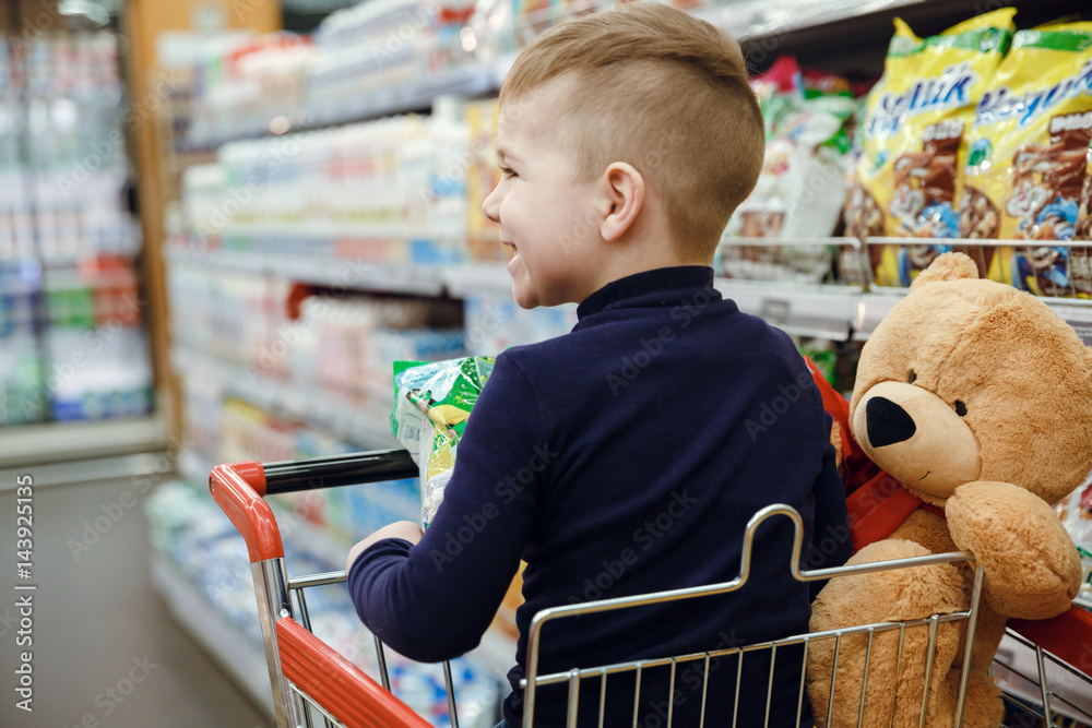 Back view of young boy in shopping trolley Stock Photo | Adobe Stock