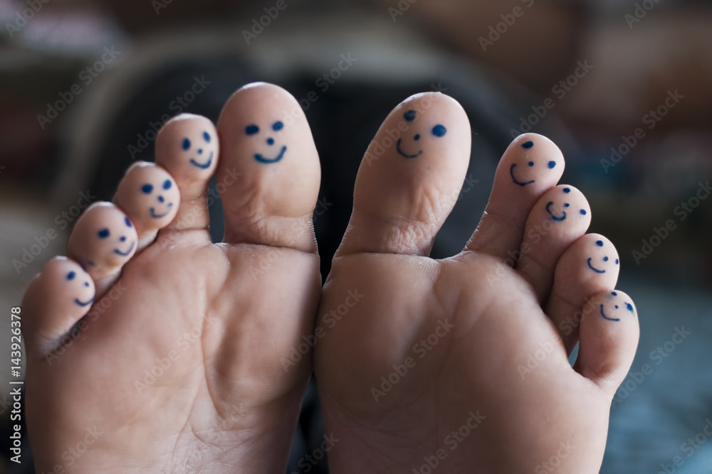 smiley face drawn on human toes. Stock Photo | Adobe Stock