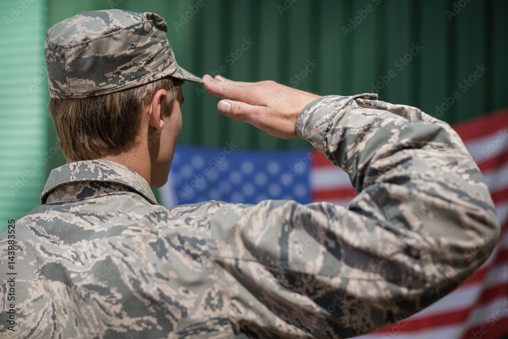 Rear view of military soldier giving salute to American flag Stock ...