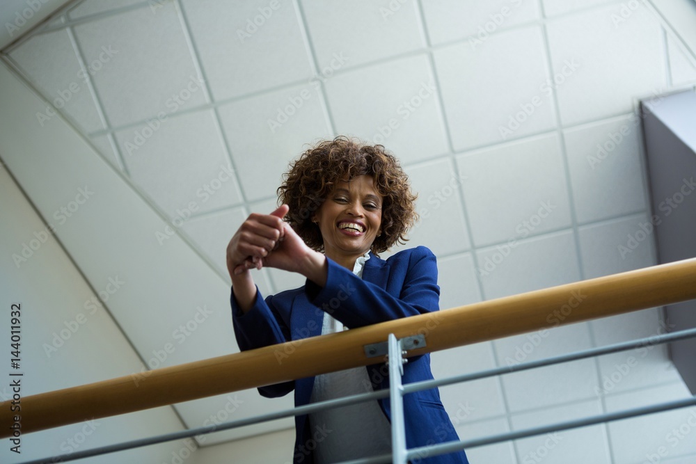 Businesswoman leaning over the railing of staircase Stock Photo | Adobe ...