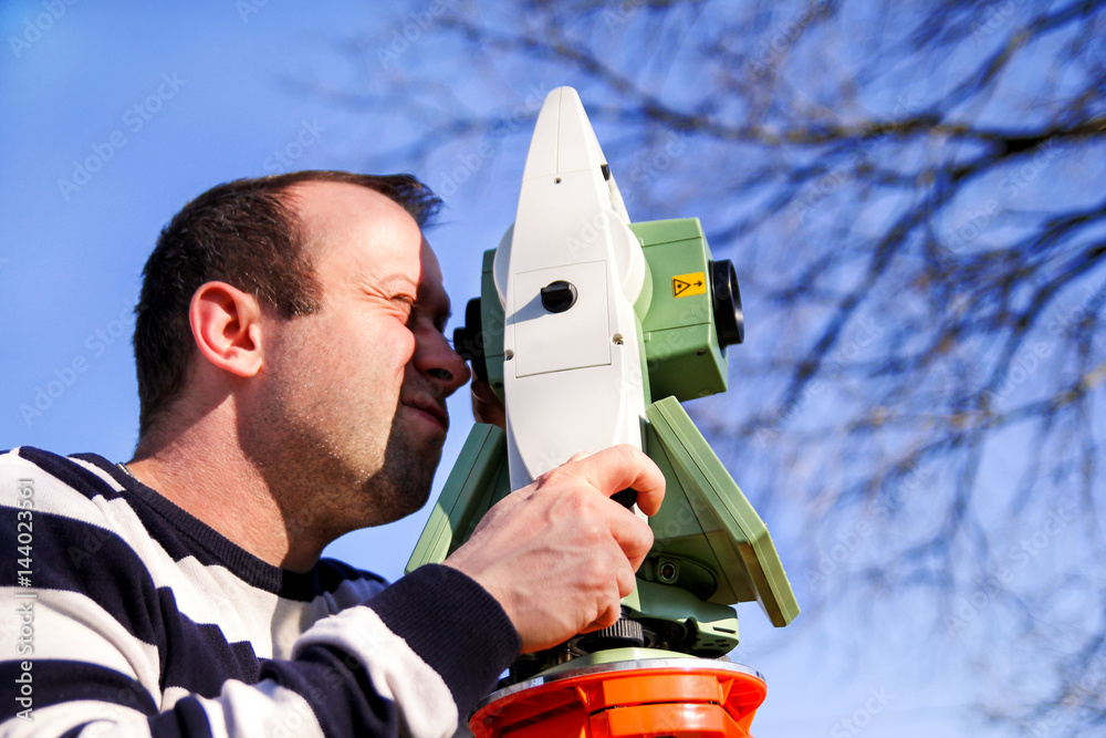 Man using of total station. Guy surveyor at work. Survey Instrument ...