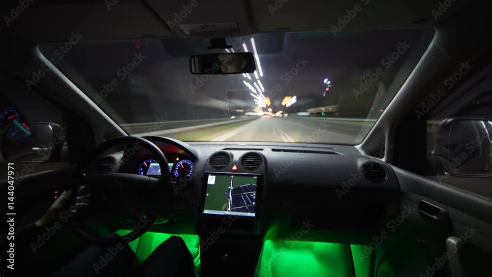 The man drive a car on the highway with a navigator. Night time ...