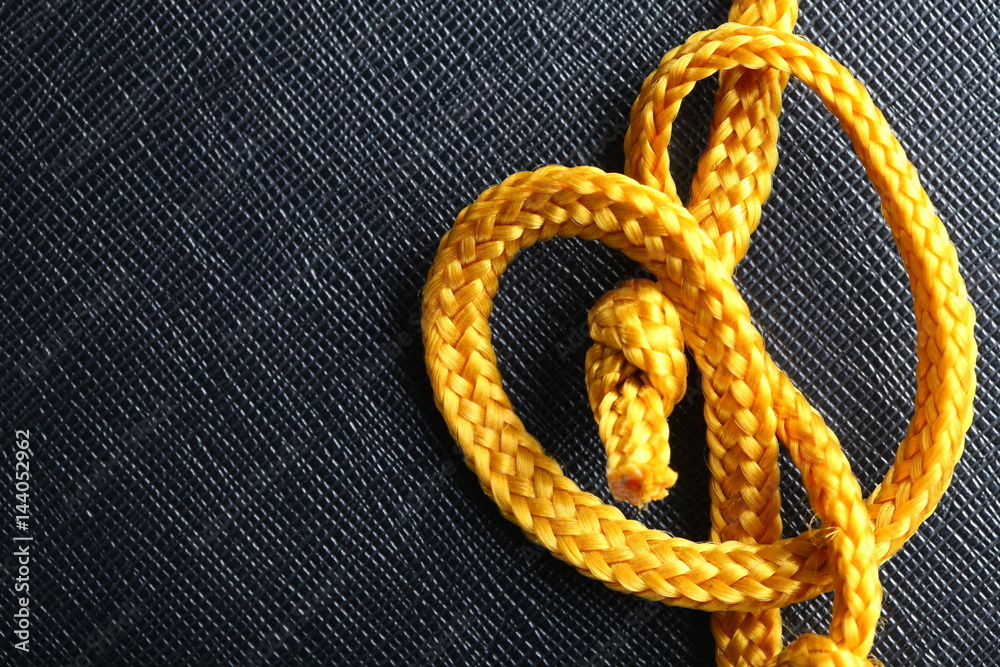 Gold color rope cable with simple knot close up photo hanging down in ...