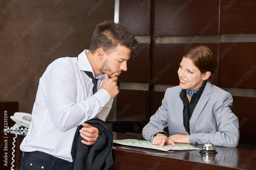 Receptionist in hotel giving advice to guest Stock Photo | Adobe Stock