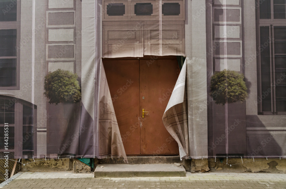 The facade of the house is closed by a banner for the time of repair ...