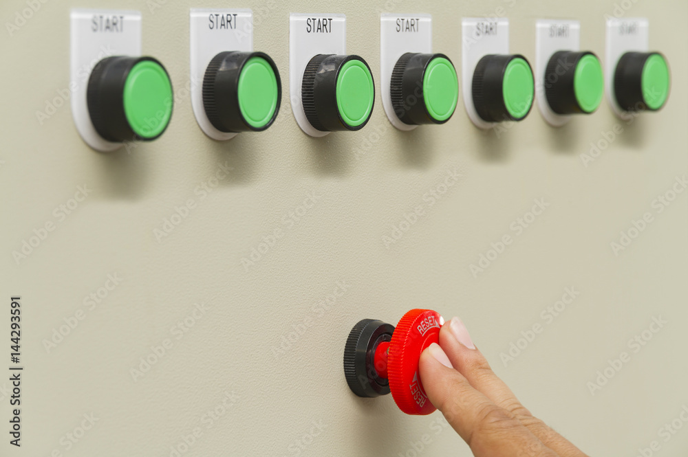 Foto de Finger touch on red emergency stop switch and reset button on ...