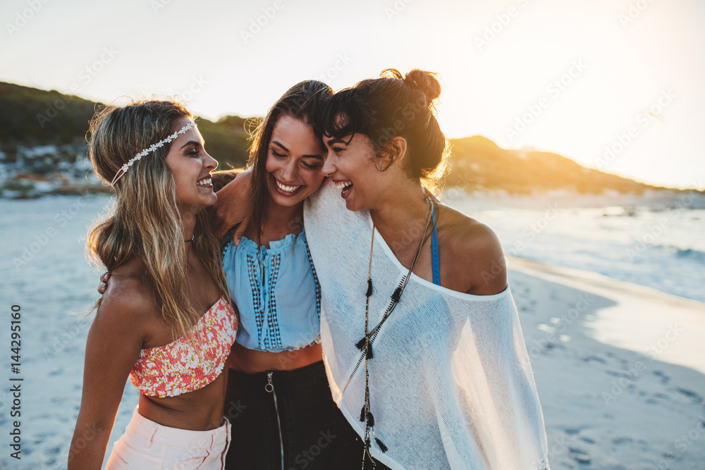 Stylish young women on beach at sunset Stock Photo | Adobe Stock