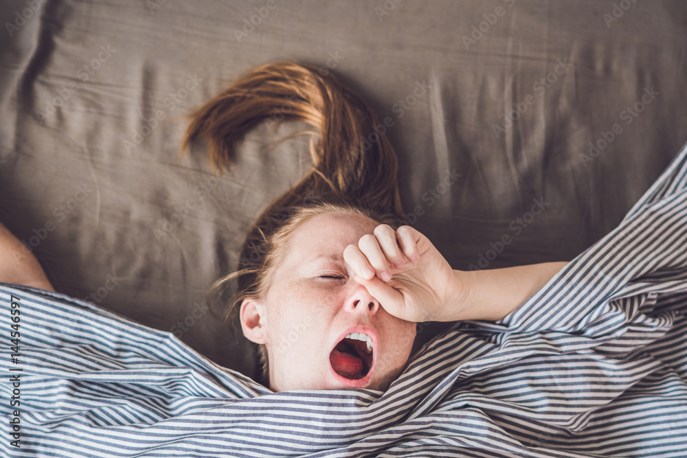 Beautiful young woman lying down in bed and sleeping, top view. Do not ...