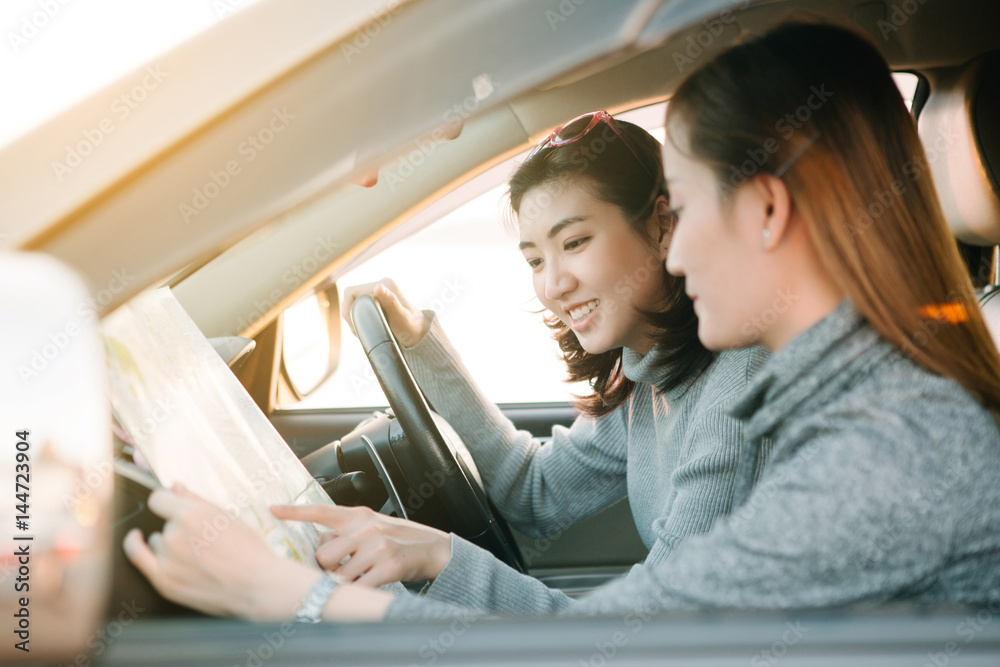 Lost with map two young Asia woman friends in car enjoy road trip Stock Photo | Adobe Stock