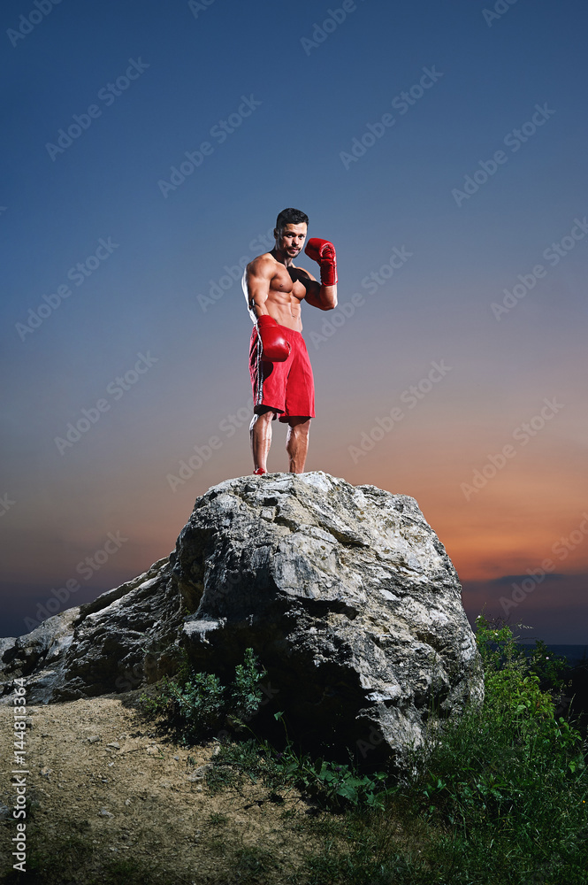 Young muscular boxer posing shirtless outdoors standing on top of a ...