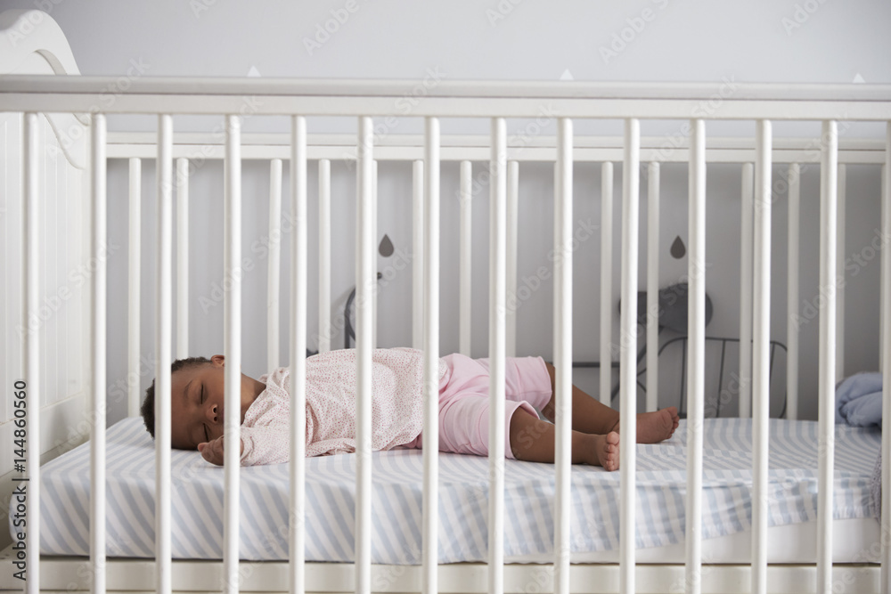 Photo Side View Of Baby Girl Sleeping In Nursery Cot, Monkey Business ...
