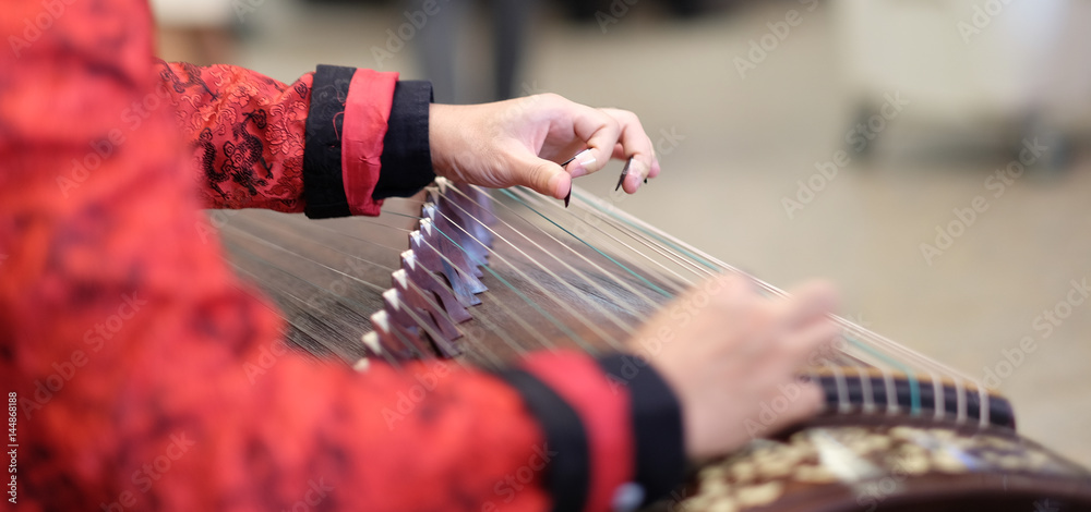 hand of man playing Guzheng.The guzheng or gu zheng, also simply called ...