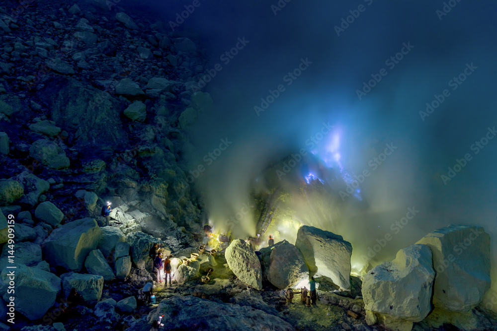 Sulfur mining at Ijenin the night. Blue flame of burning sulfur in the ...