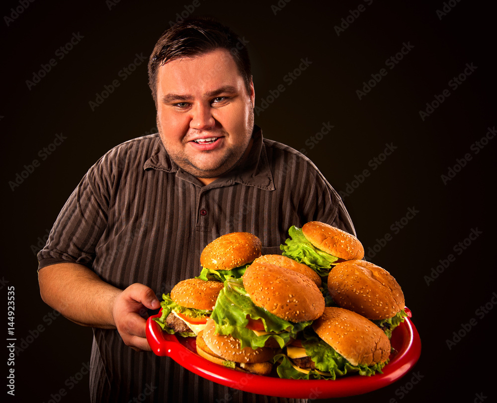 Fat man eating fast food hamberger and carries treat for friends on ...