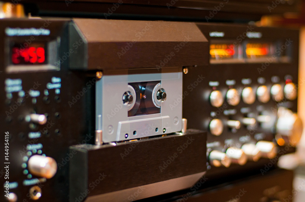 Old compact audio cassette in vintage audio system with tape recorder ...