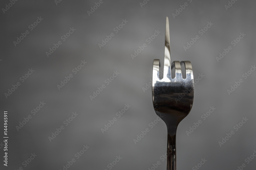 Fork bent in the form of an obscene gesture sign of the middle finger ...