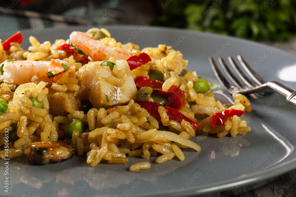 Traditional seafood paella with shrimp, fish and chicken seved in plate ...