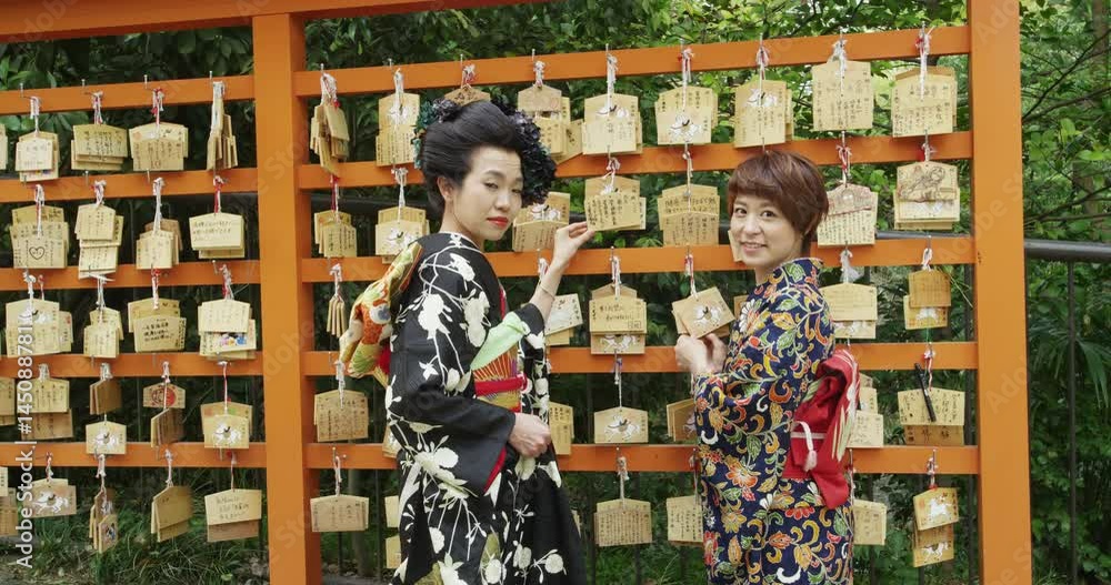 A Japanese Woman with Ema wooden plaques where prayers and wishes are ...
