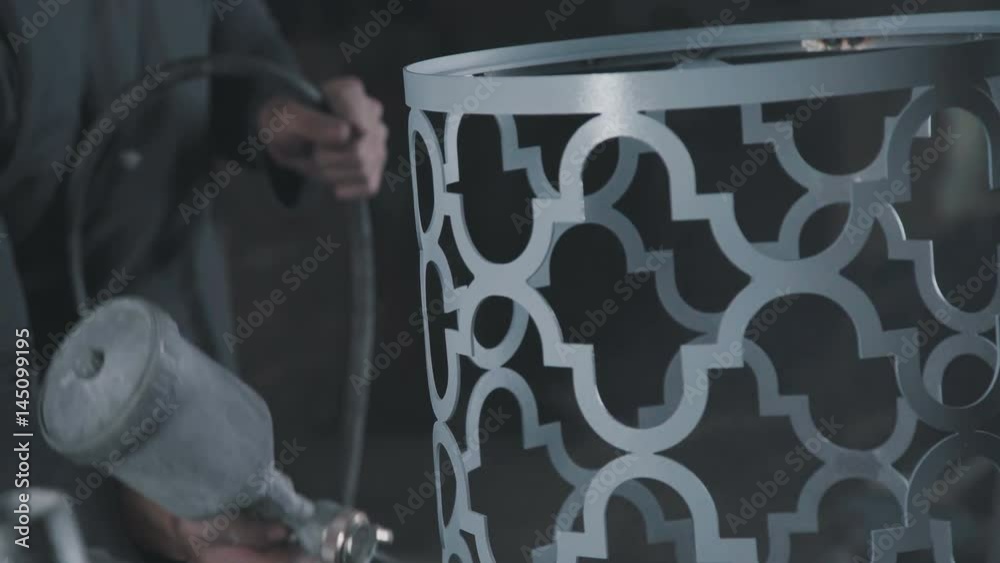 Painting a metal decorative element in gold and gray using a spray gun ...