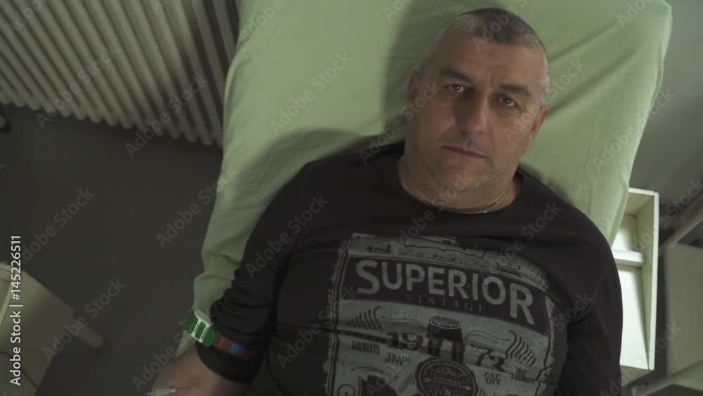 Crane shot from middle aged man face close up while he lying on the bed ...