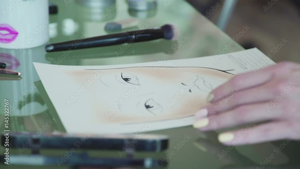 A woman make-up artist learns to apply make-up using the face map. The ...