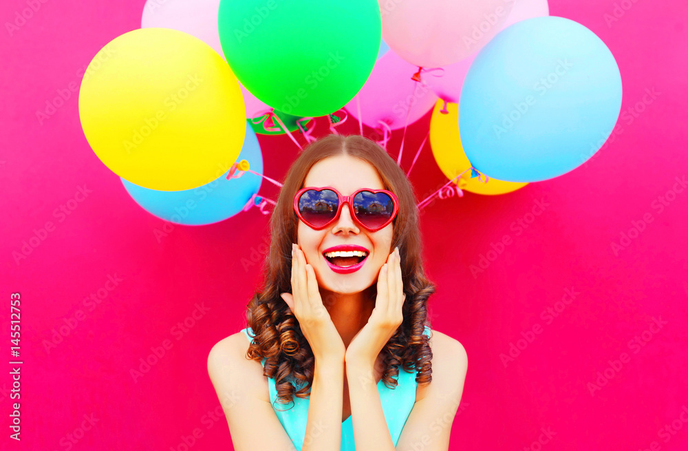 Portrait happy smiling young woman is having fun over an air colorful ...