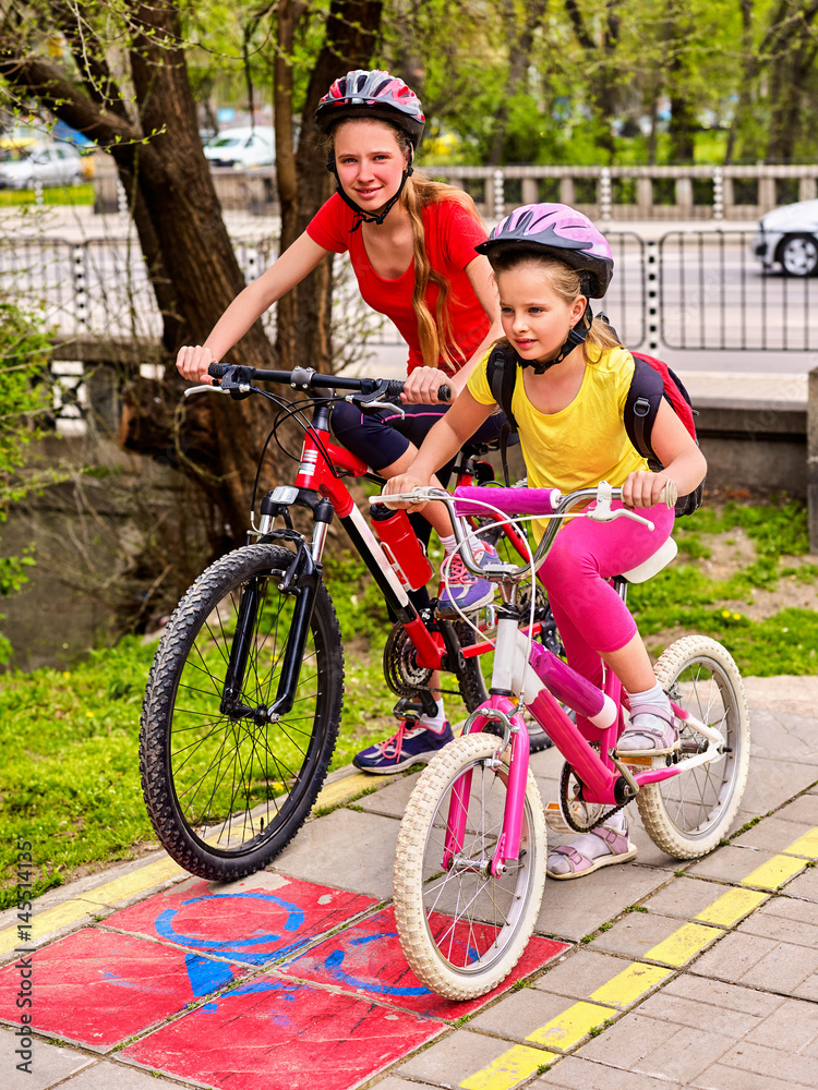 Bicycle path and sign with children. Girls wearing bicycle helmet with ...