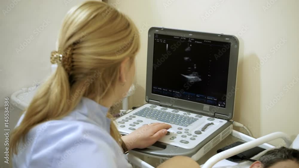 Echocardiography. Female doctor examining a patient's heart by using an ...