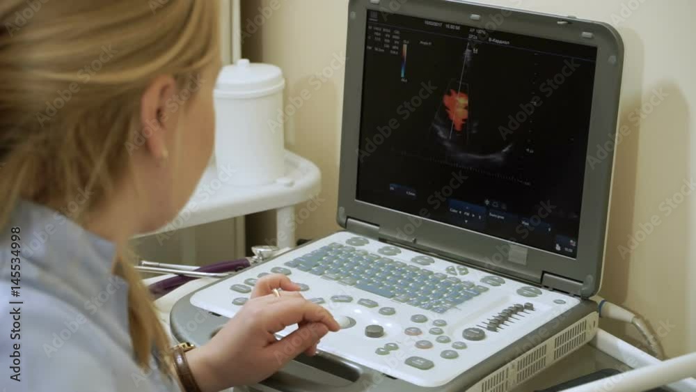 Echocardiography. Female doctor examining a patient's heart by using an ...