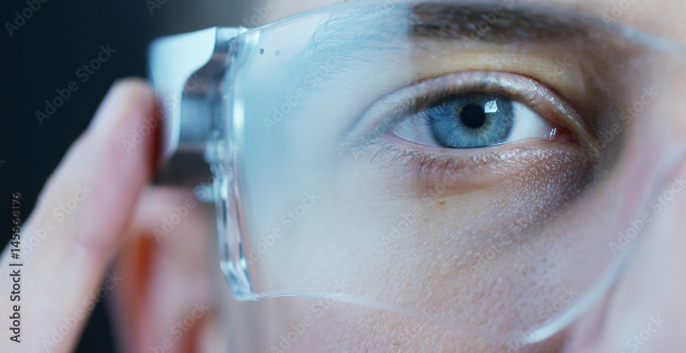 Close up of a scientist with futuristic graphics with which scans and ...