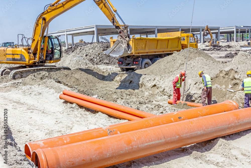 Placing new plastic pipes into the ground Stock Photo | Adobe Stock