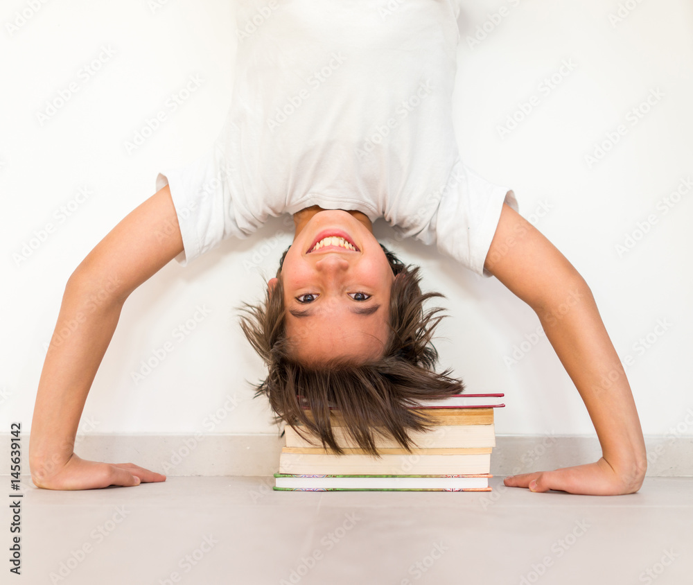 Kid with school books upside down education concept Stock Photo | Adobe ...