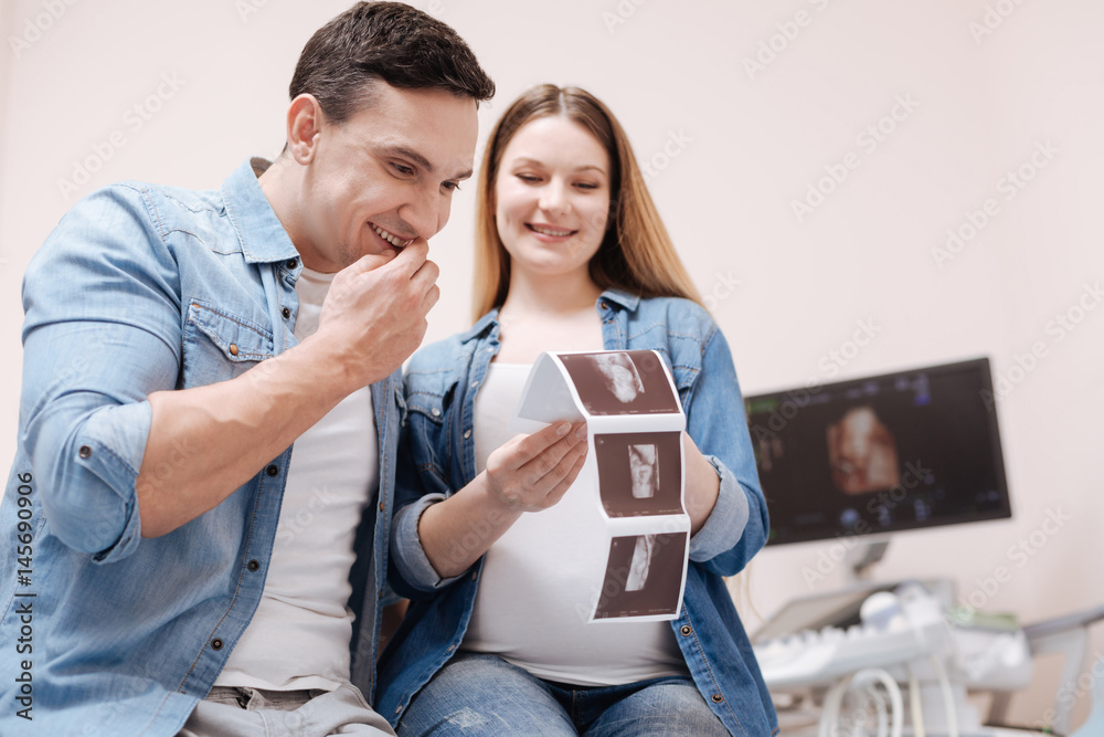 Young future parents admiring ultrasound digital pictures of future ...