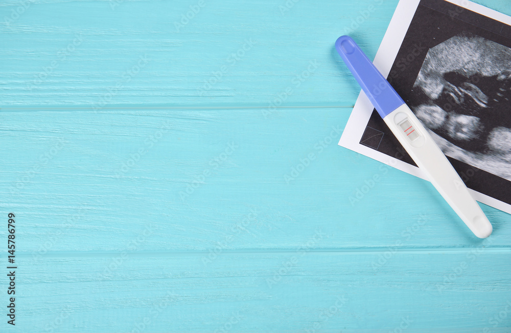 Ultrasound photo and pregnancy test on blue wooden background Stock ...