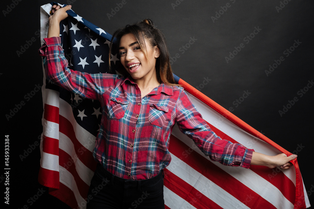 Upbeat Hispanic American woman holding American symbol indoors Stock ...