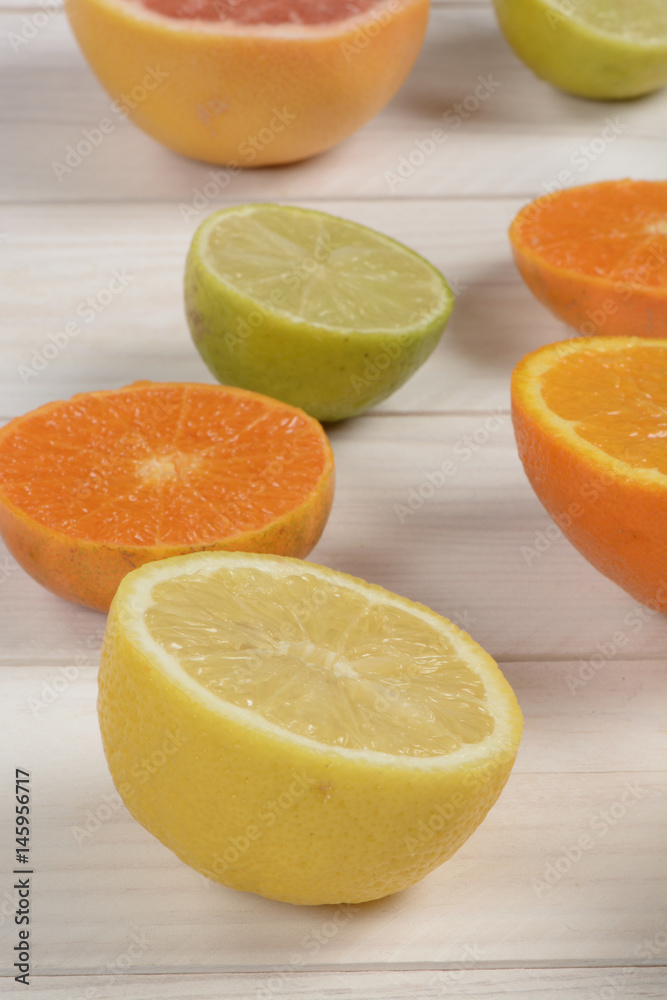 Limón cortado a la mitad sobre fondo de madera blanca y otras frutas ...