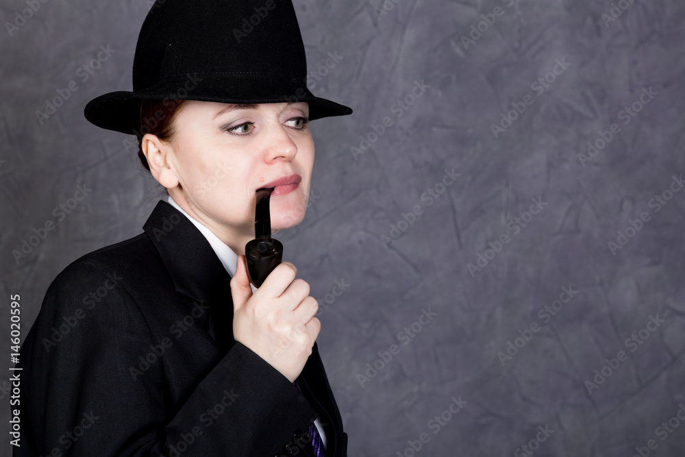 beautiful woman in manly style with smoking pipe on gray background ...