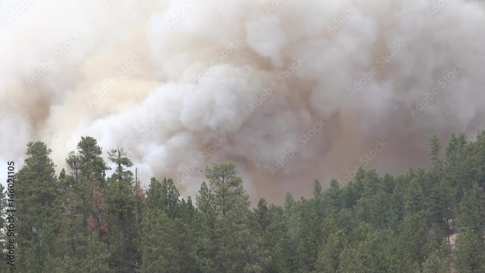 CLOSE UP: Thick black smoke trail rising and spreading fast across the ...