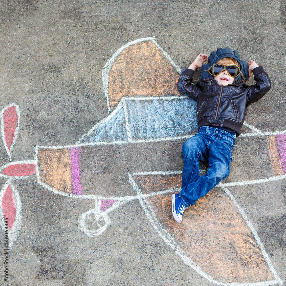 Little boy having fun with airplane picture drawing with chalk Stock ...