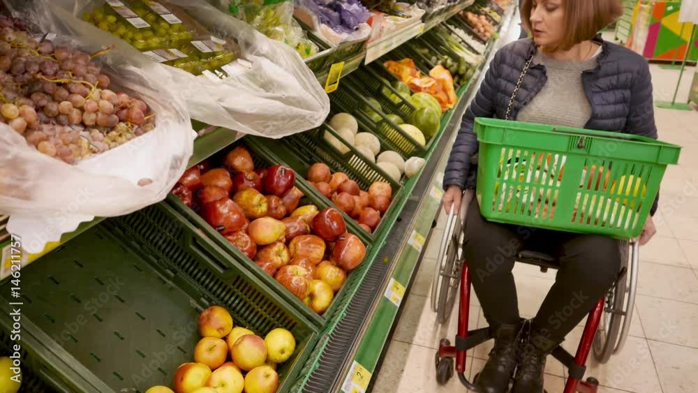 Disabled woman in a wheelchair choosing fruits and vegetables Stock ...
