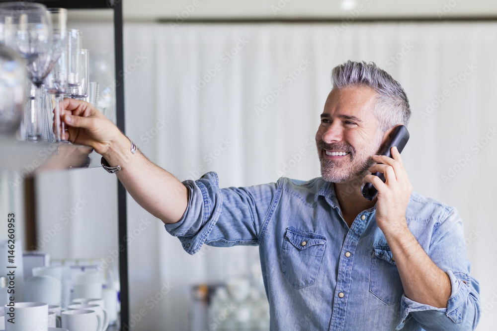Man touching glasses in store while talking on telephone Stock Photo ...