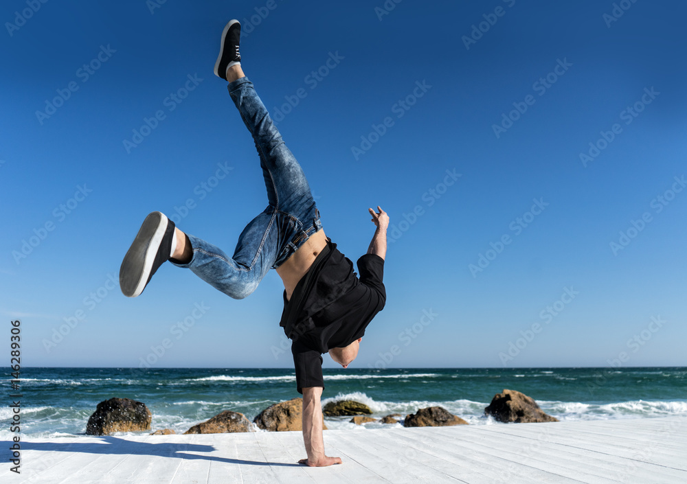 Young Athlete doing one arm handstand on the beach. Street workout ...