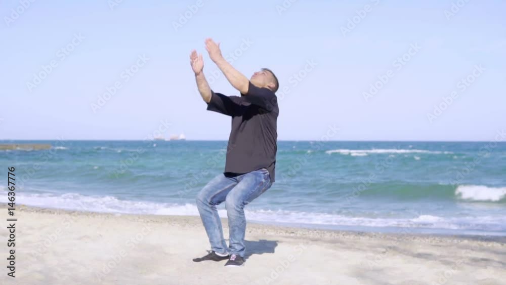 Male gymnast performing free running style backflip on beach ...