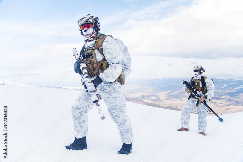 Army servicemen in winter camo somewhere in the mountains. Walking ...