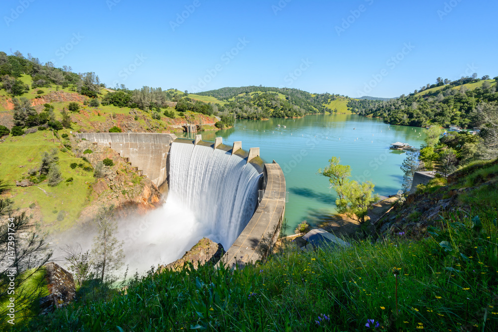 Water spills over the top of Englebright Dam on the Yuba River. A ...