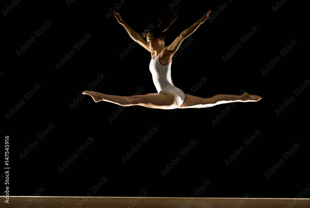 gymnast jumping on beam Stock Photo | Adobe Stock