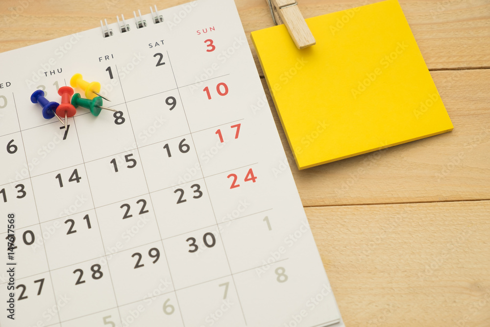 top view. pin putting on desktop calendar and have post-it note put on ...