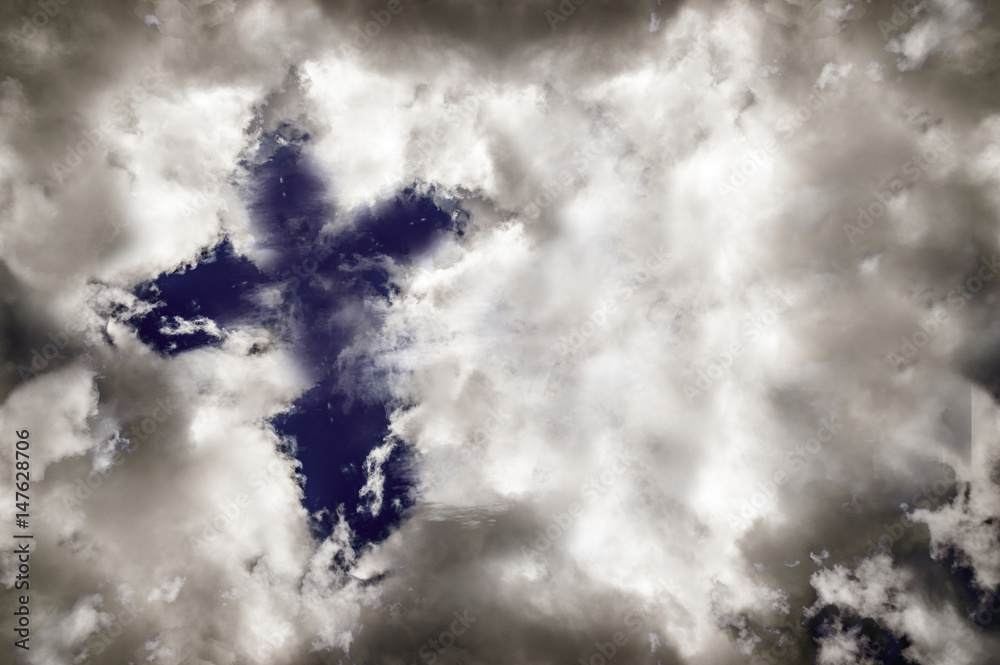 Dark blue sky in shape of a cross with white and grey clouds, abstract ...