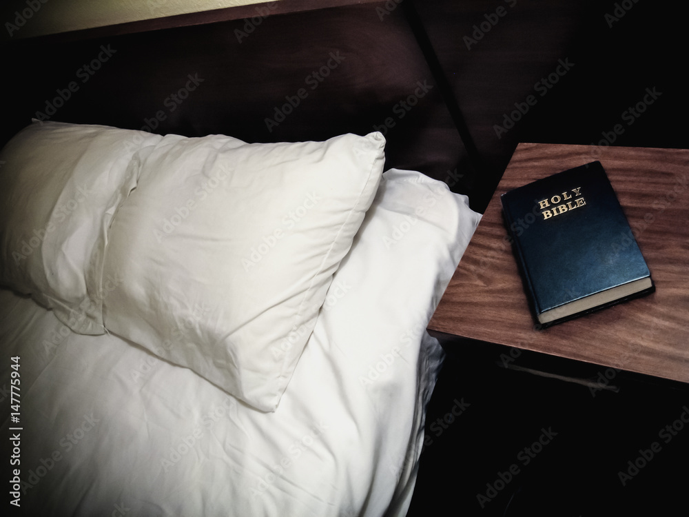 Holy Bible Nightstand Motel Room. Motel room bed with a bible on a the ...