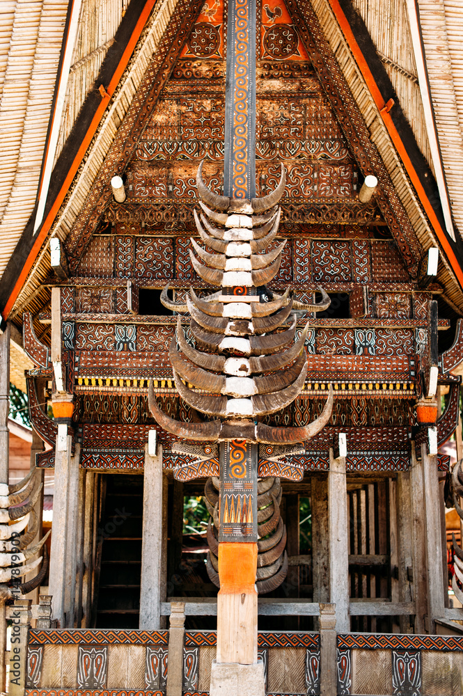 Part of tongkonan house with horns of buffaloes and wood carving and ...